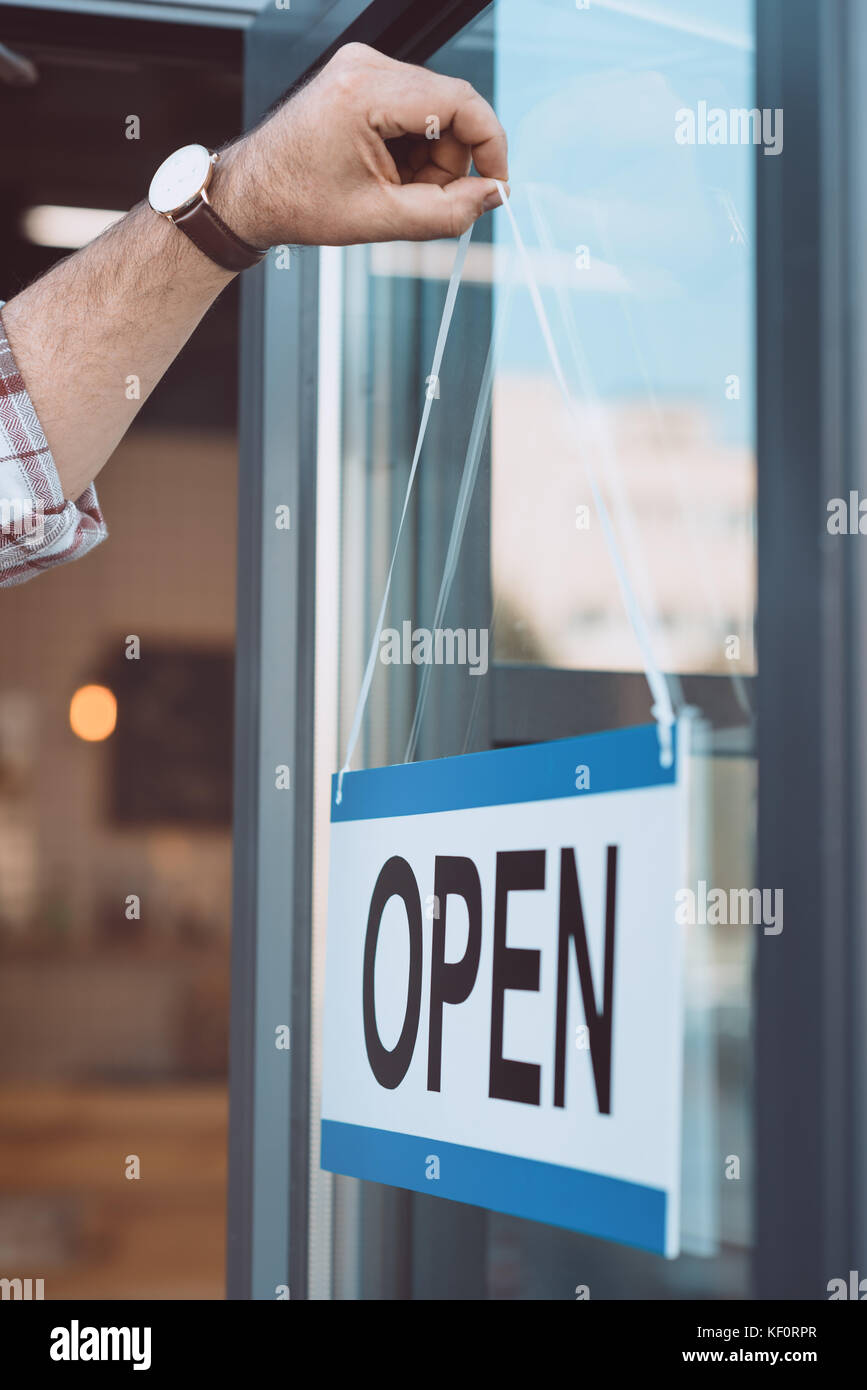 man hanging open signboard Stock Photo - Alamy