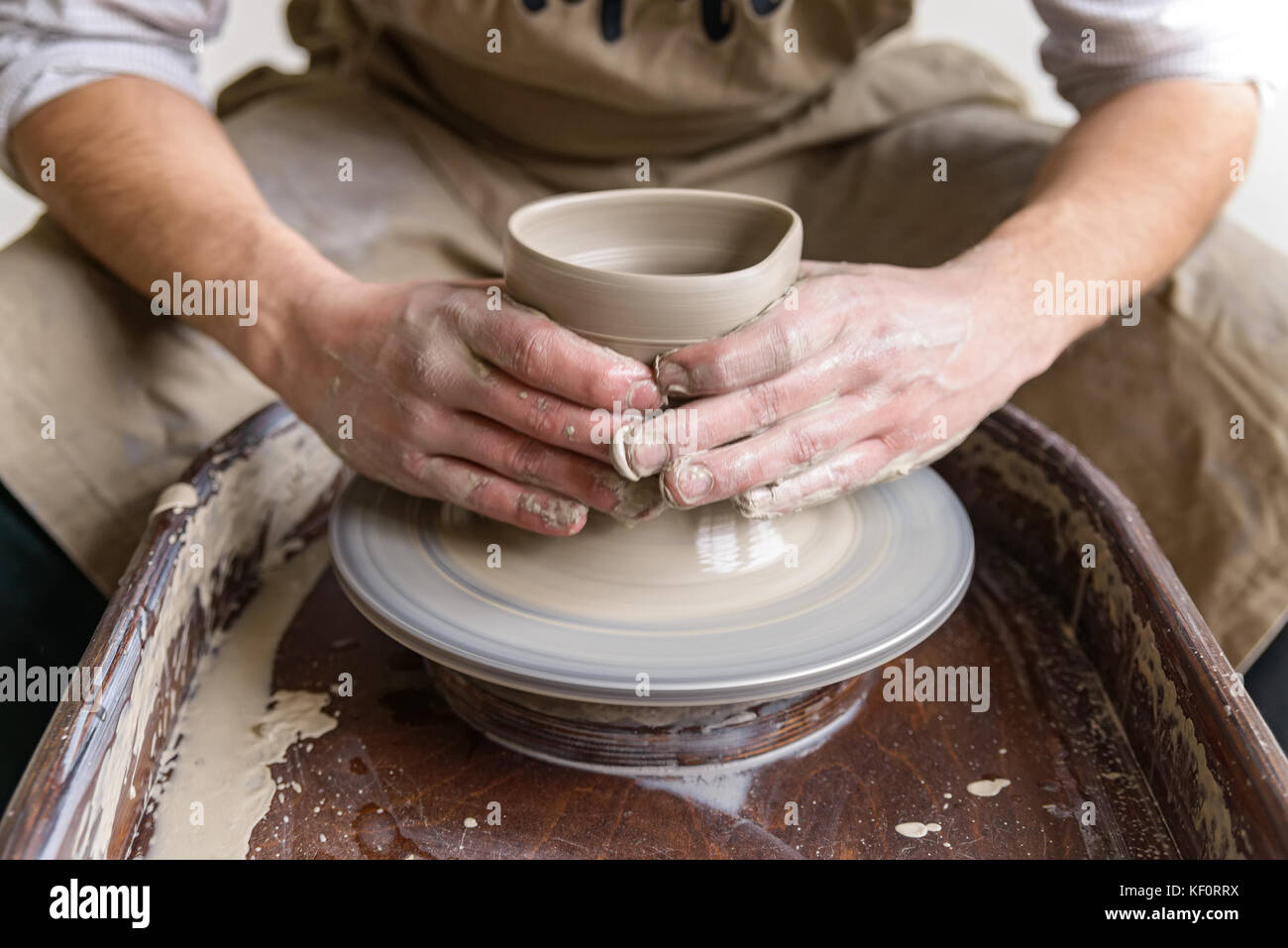 Hands working on pottery wheel Stock Photo - Alamy