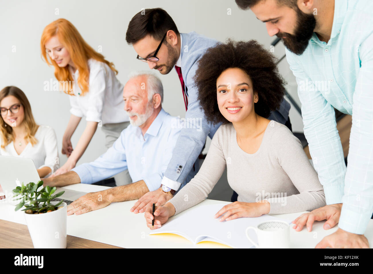 View of multiracial business people around table during staff meeting ...