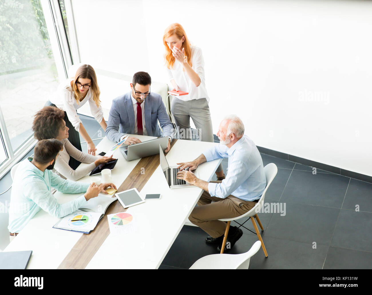 View of multiracial business people around table during staff meeting ...