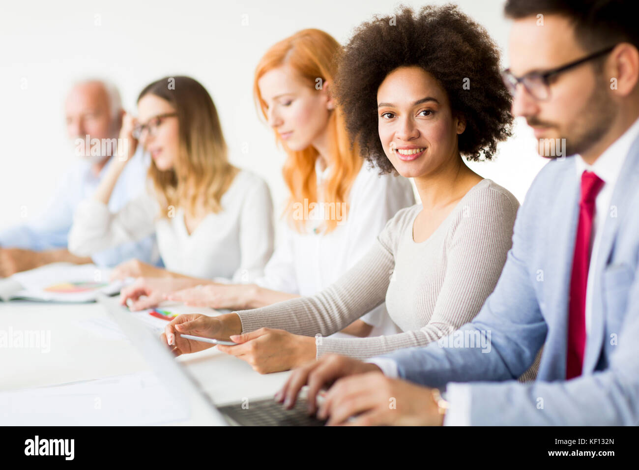 View of multiracial business people around table during staff meeting ...