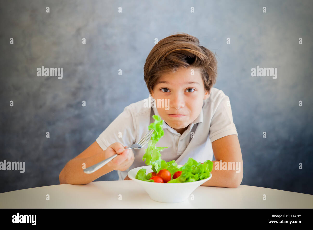 Portrait of teen boy refuses to eat salad Stock Photo - Alamy