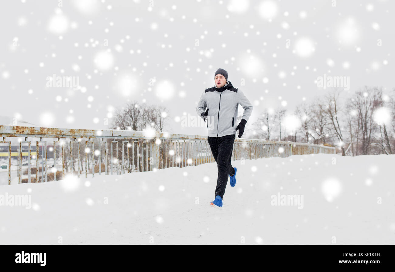 man running along snow covered winter bridge road Stock Photo - Alamy
