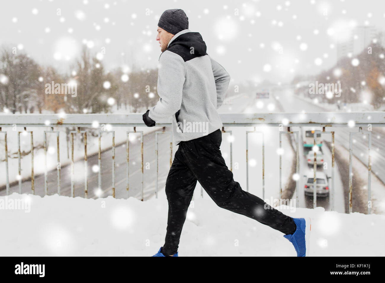 man running along snow covered winter bridge road Stock Photo - Alamy