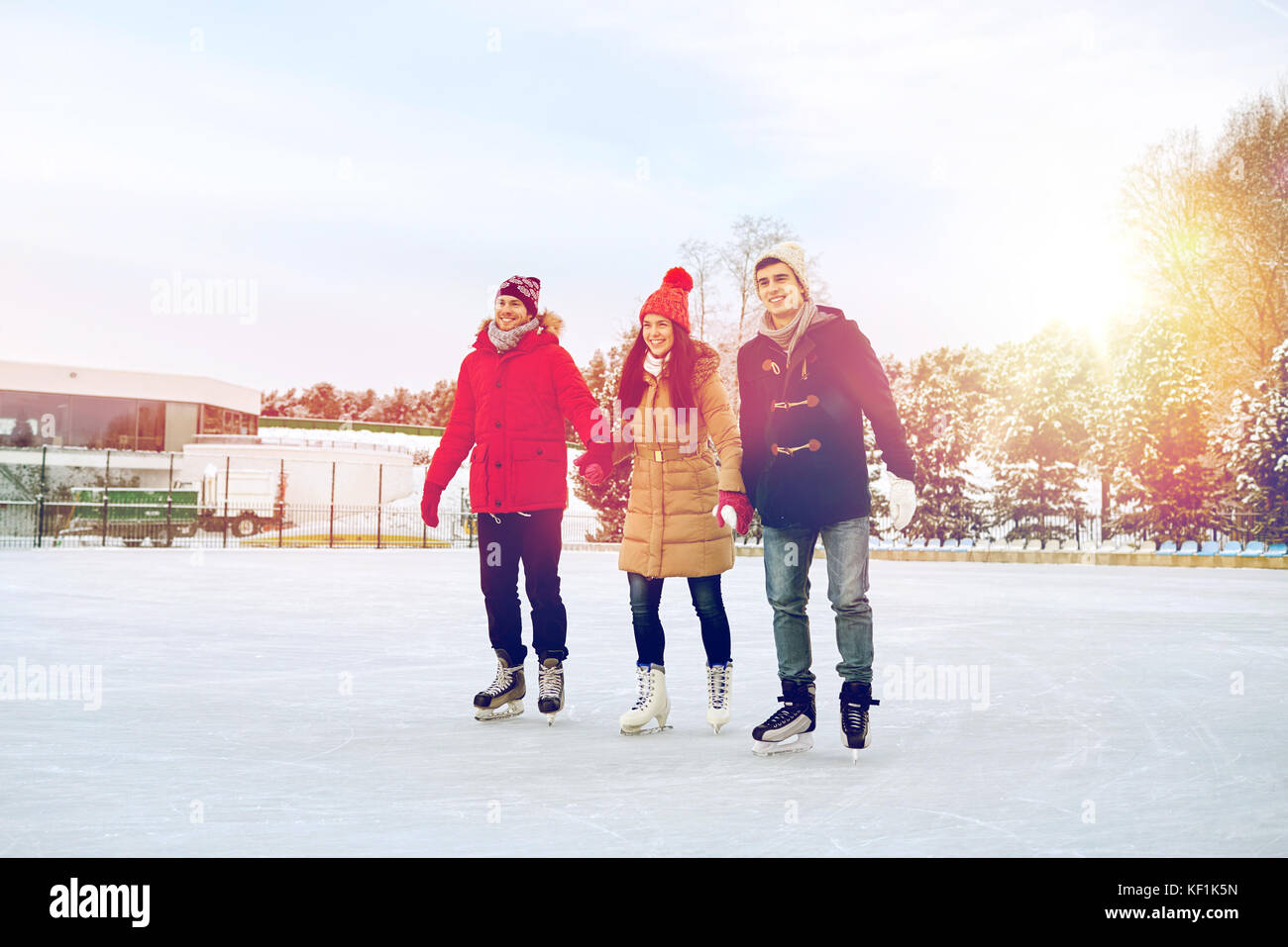 happy friends ice skating on rink outdoors Stock Photo - Alamy