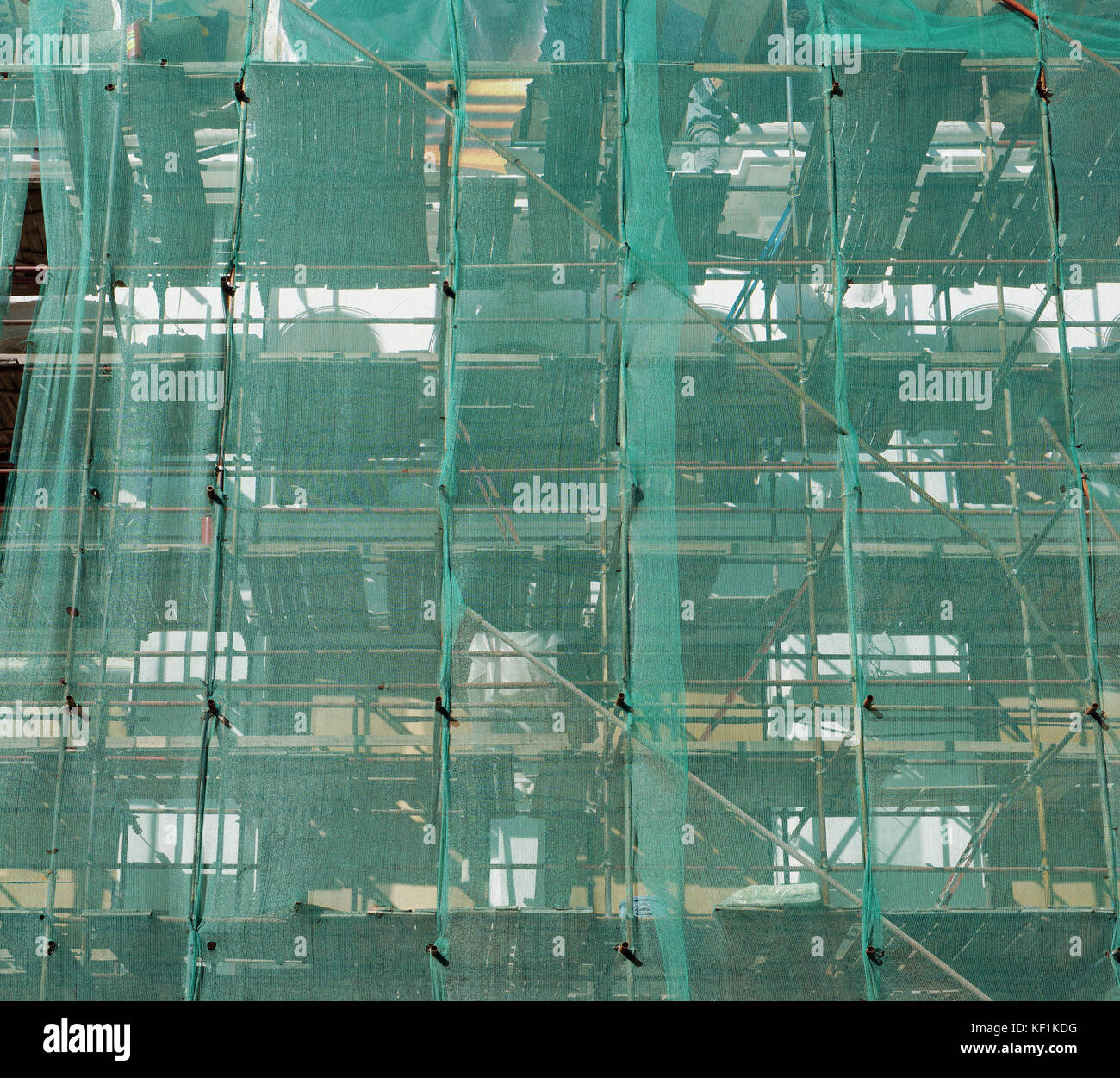 Green plastic mesh on the wall of a renovated urban building protects ...