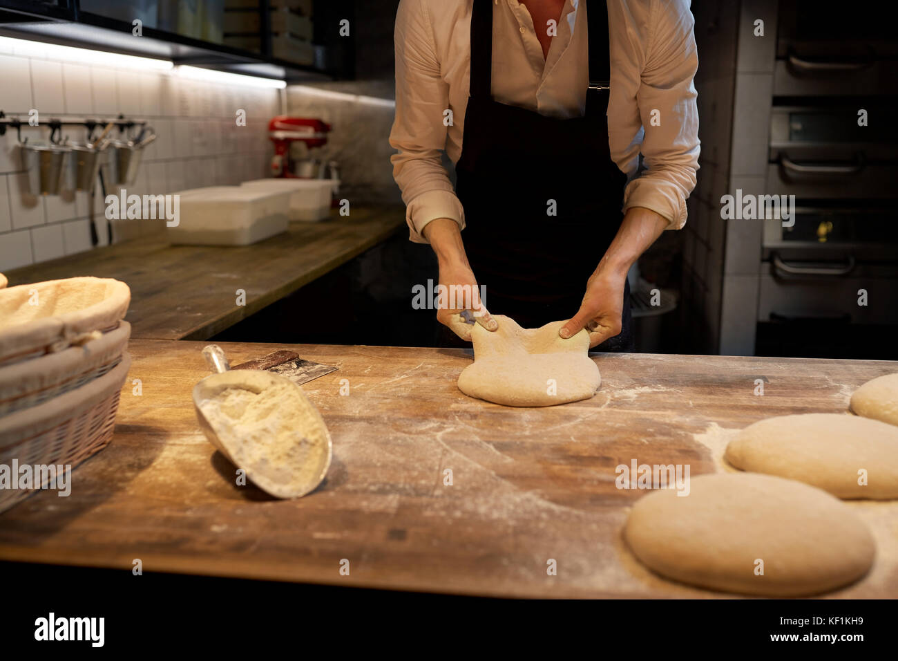 baker portioning dough with bench cutter at bakery Stock Photo - Alamy
