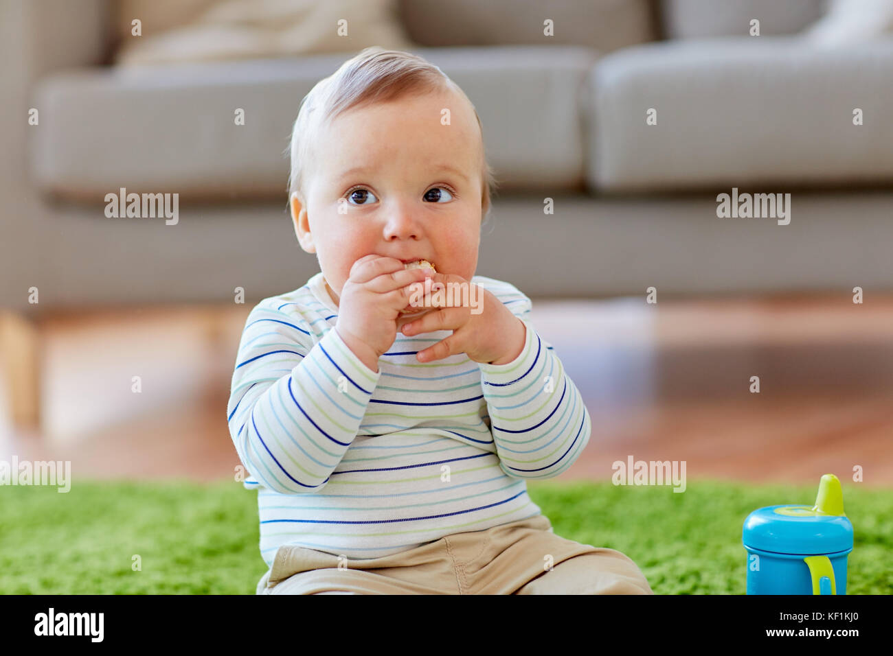 baby boy on floor and eating rice cracker at home Stock Photo - Alamy