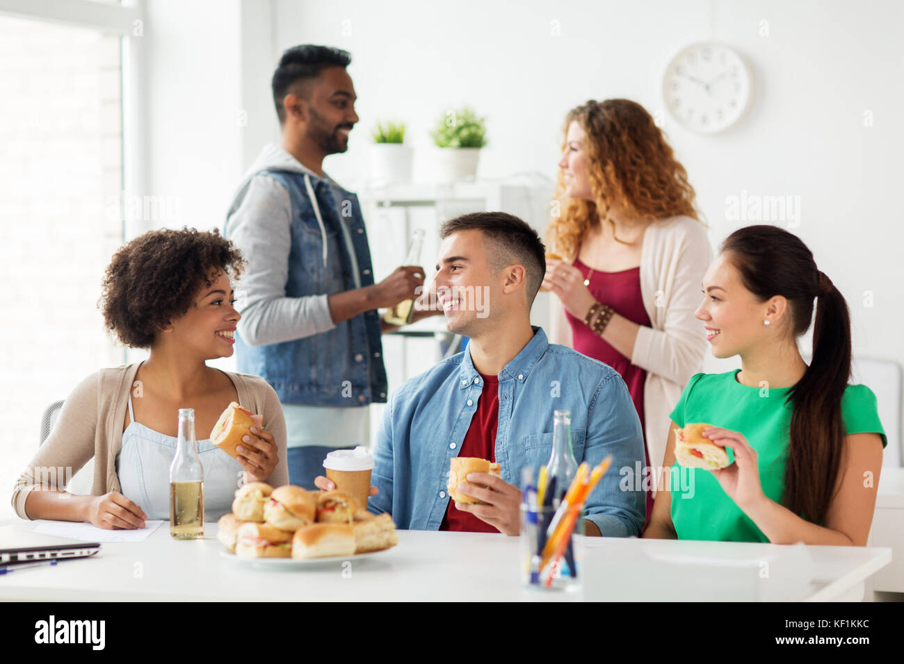 happy friends or team eating at office party Stock Photo - Alamy