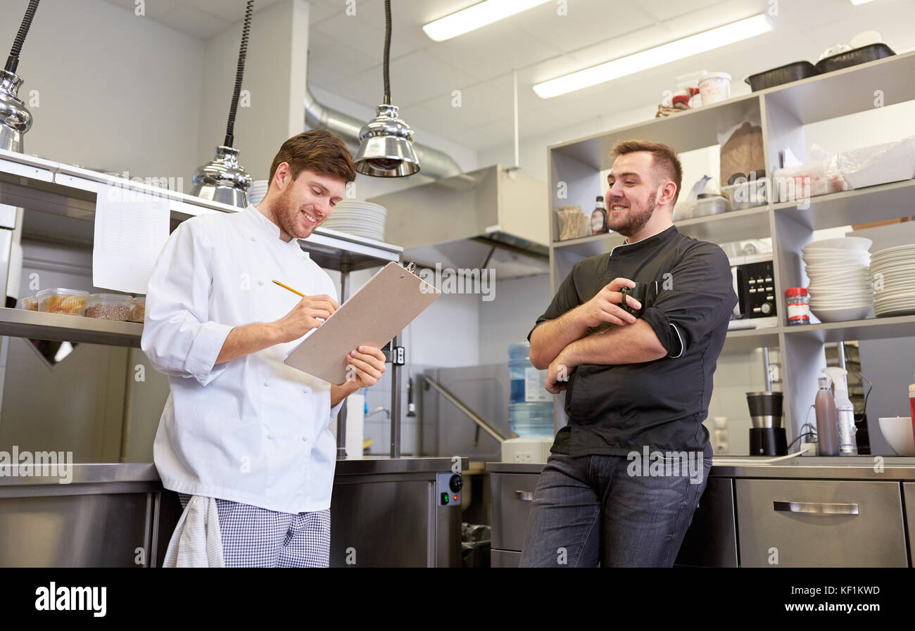 happy smiling chef and cook at restaurant kitchen Stock Photo - Alamy