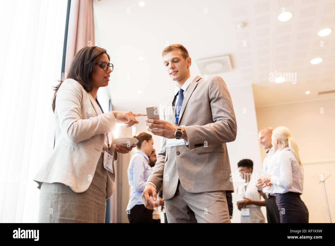 couple with smartphone at business conference Stock Photo - Alamy
