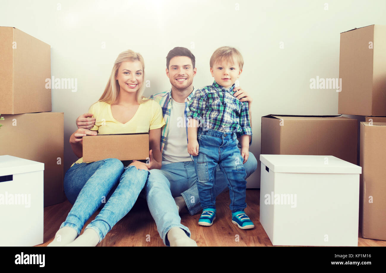happy family with boxes moving to new home Stock Photo - Alamy