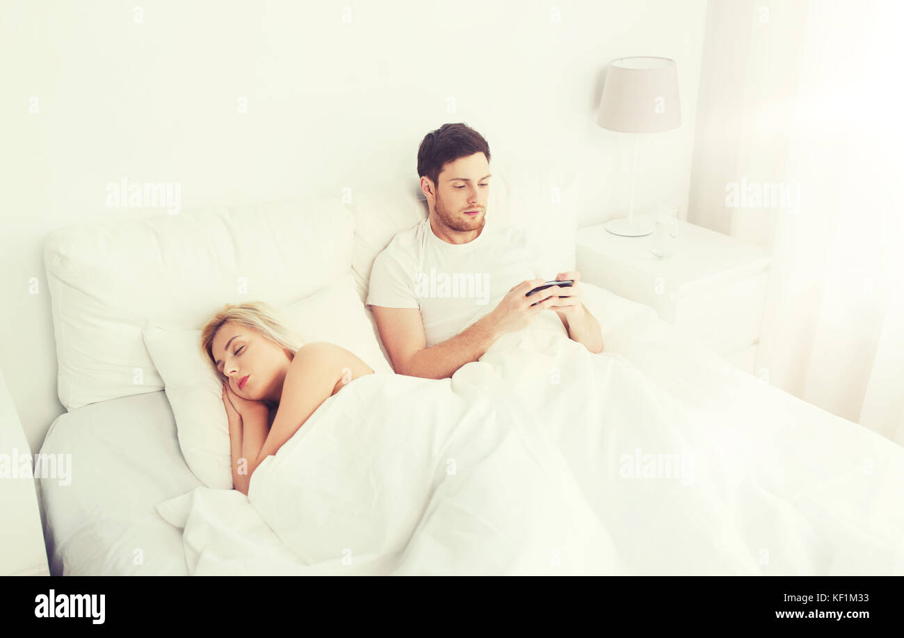 man texting message while woman is sleeping in bed Stock Photo - Alamy man texting message while woman is sleeping in bed Stock Photo - Alamy