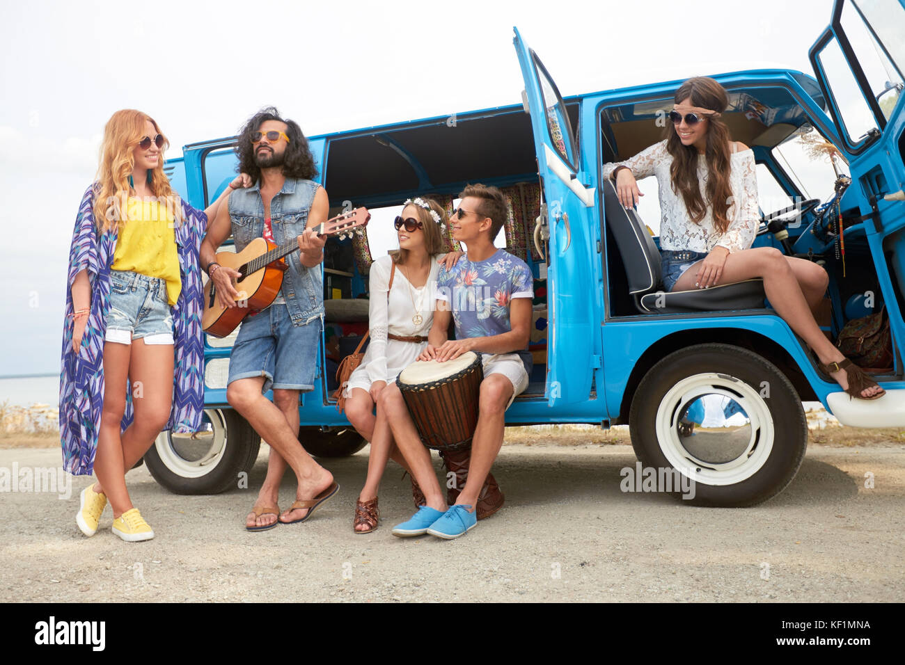 happy hippie friends playing music in minivan Stock Photo - Alamy