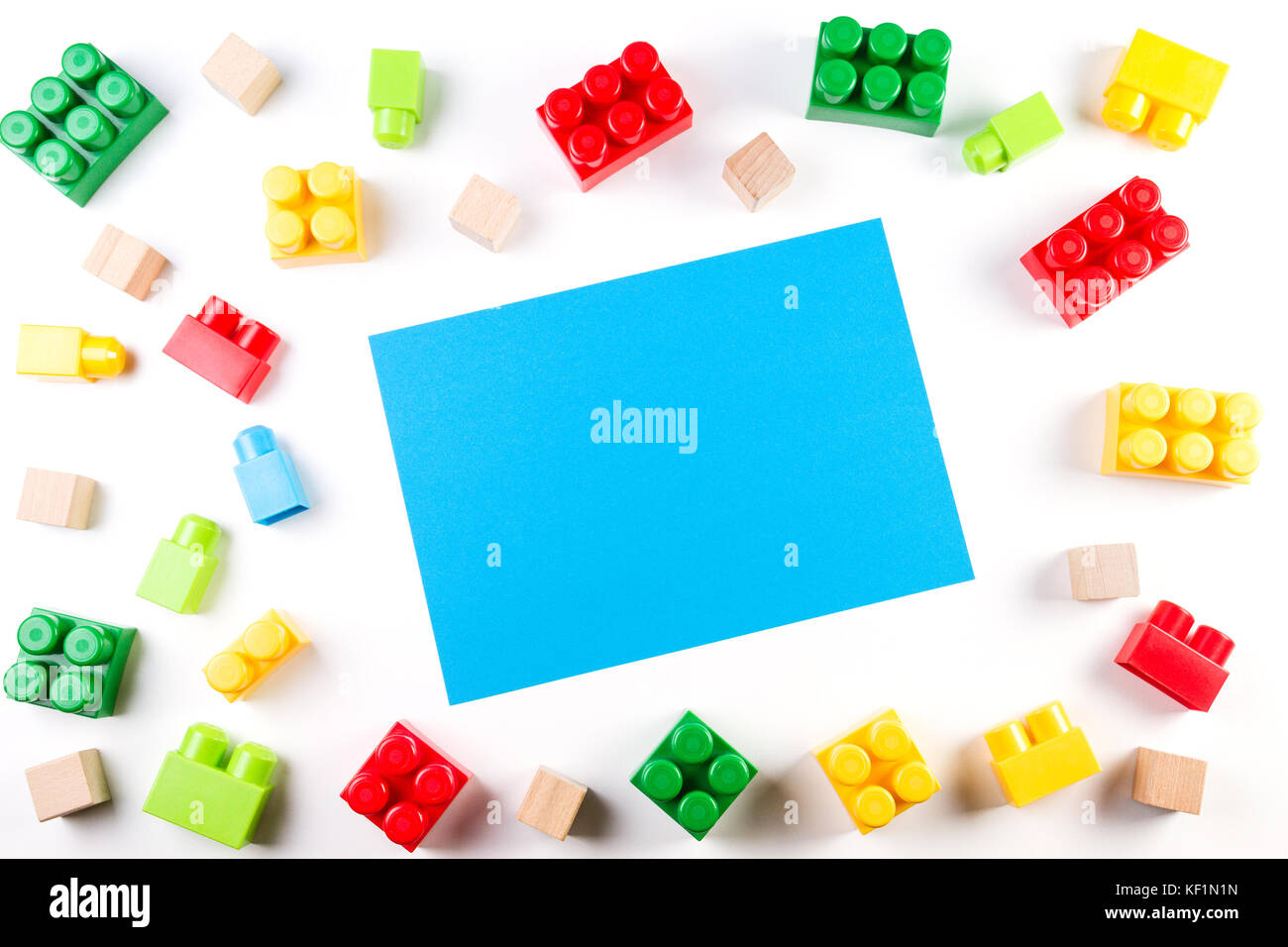 Colorful wooden cubes and plastic construction blocks with blue blank ...