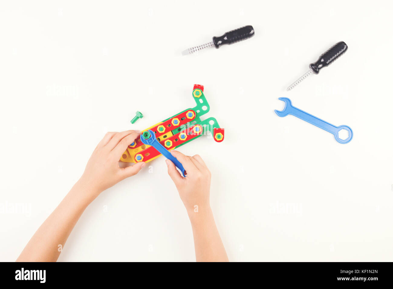 Child's hands playing with colorful toys tools on the white background ...