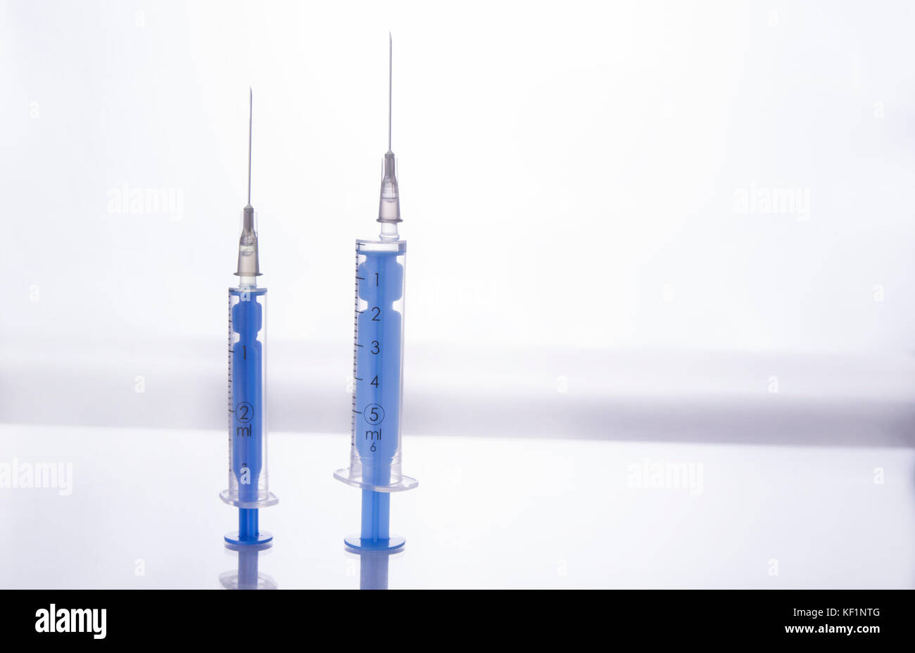 Two injections with needles stand up on white background Stock Photo ...