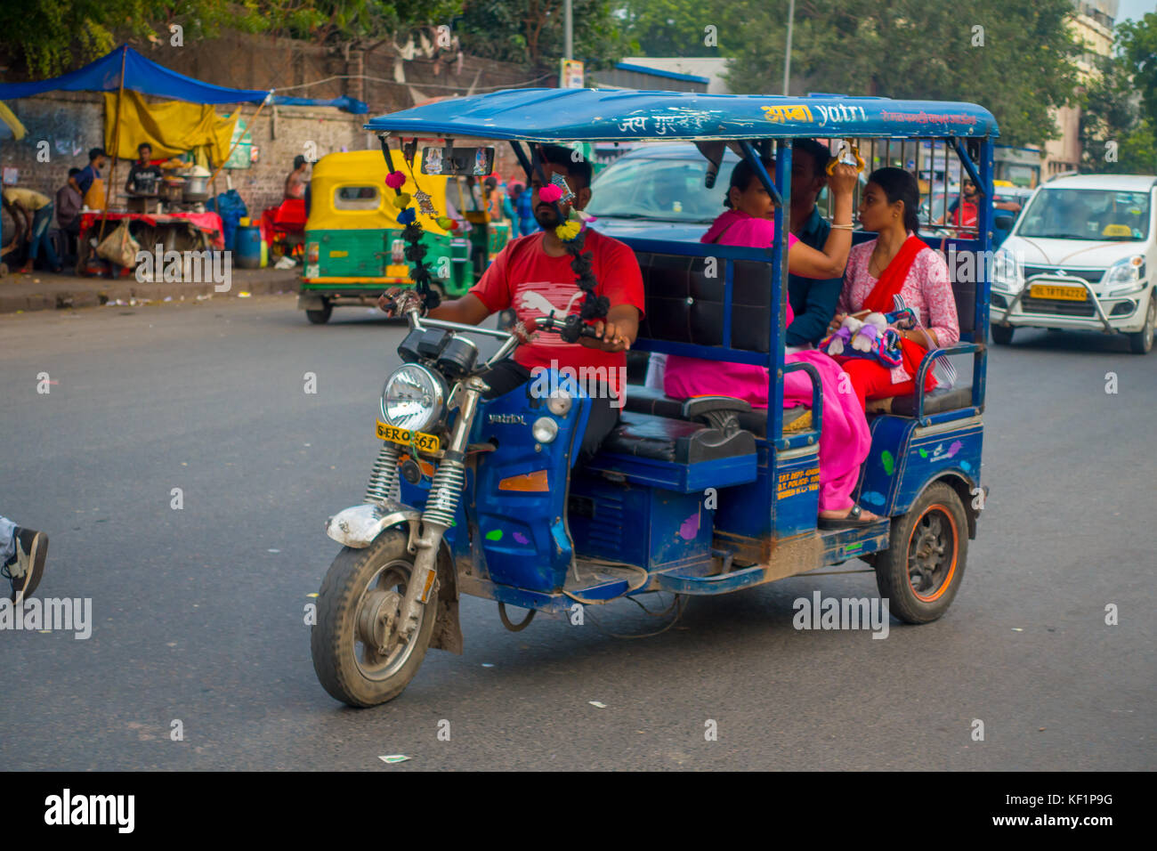 DELHI, INDIA - SEPTEMBER 25 2017: Busy street with a blue Rickshaws and ...