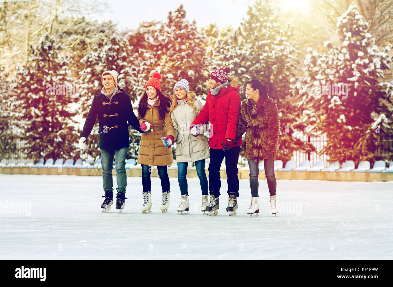 happy friends ice skating on rink outdoors Stock Photo - Alamy