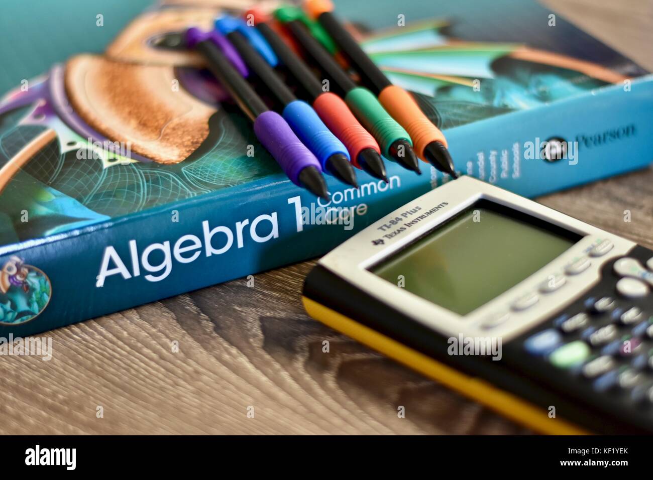 Algebra math book on desk next to classroom materials Stock Photo - Alamy