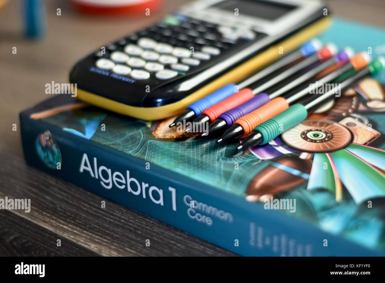 Algebra math book on desk next to classroom materials Stock Photo - Alamy