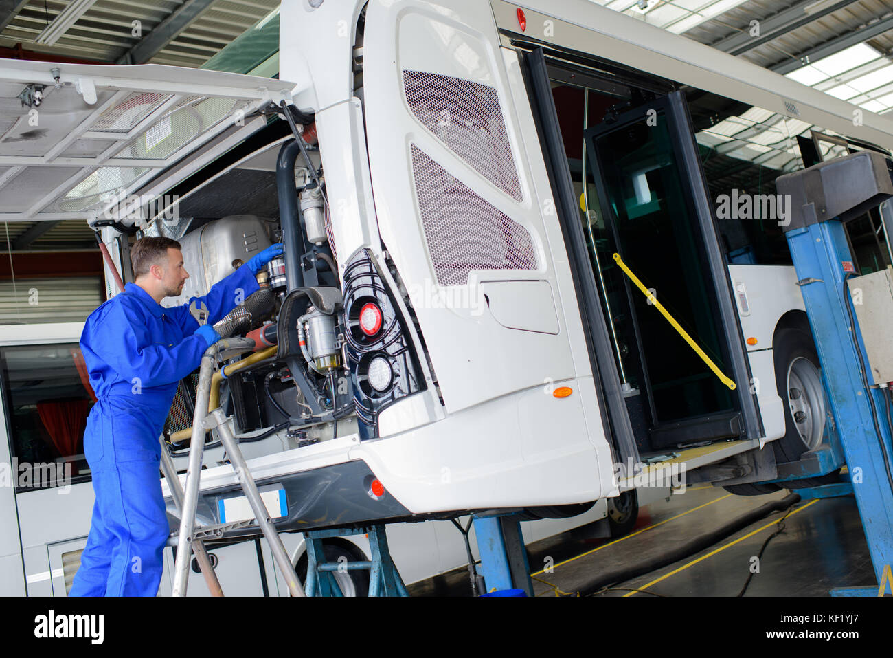 Mechanic working on engine of public transport bus Stock Photo - Alamy
