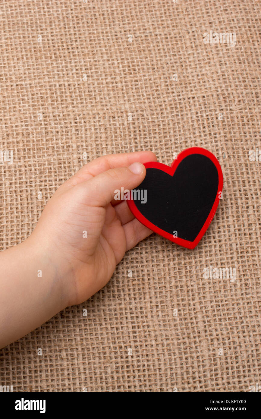 Heart shaped object in hand on canvas Stock Photo - Alamy