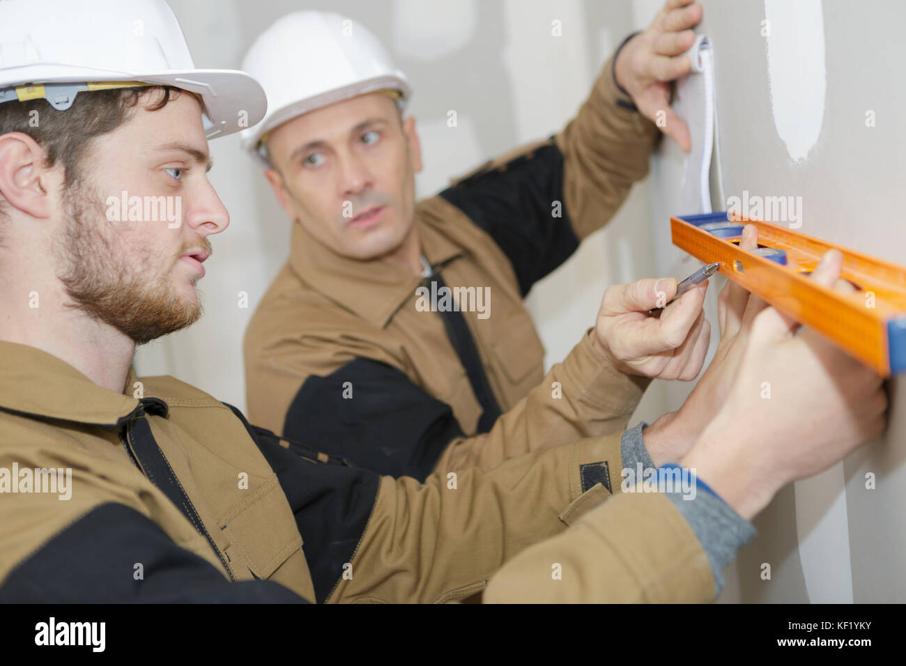 apprentice workman with a spirit level Stock Photo - Alamy