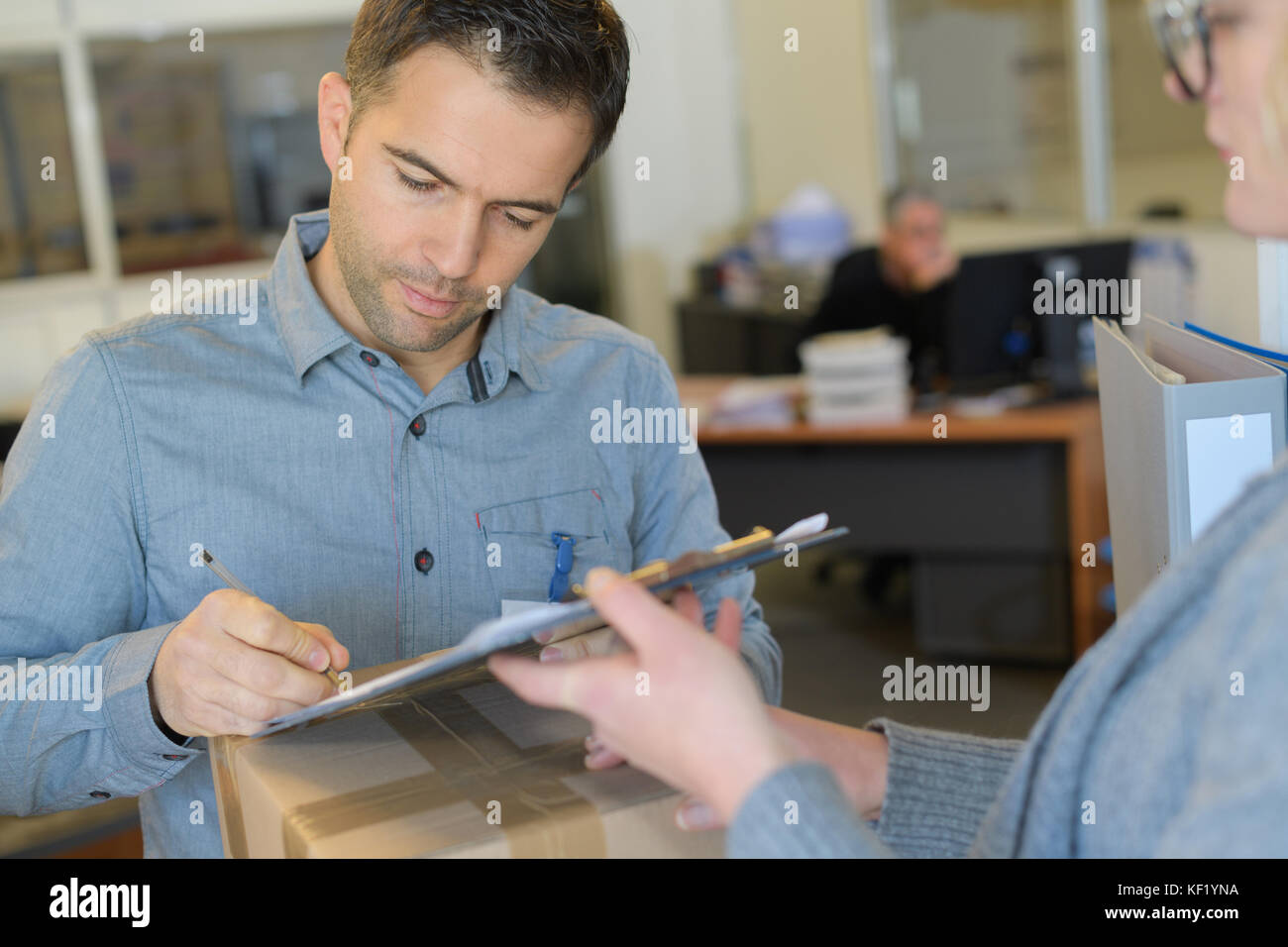 worker signing the delivered box Stock Photo - Alamy