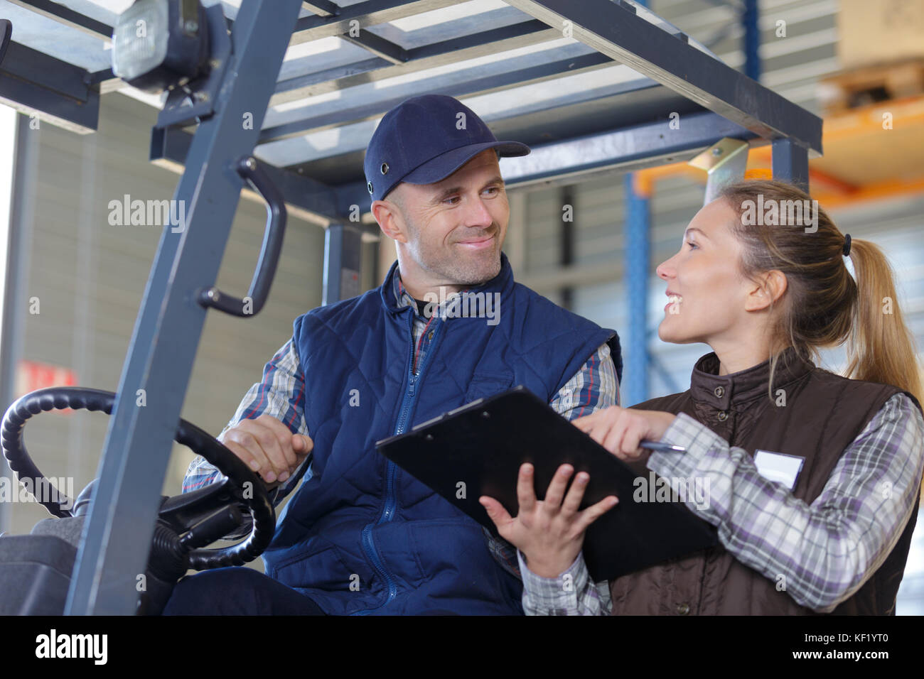 workers in logistics warehouse at forklift checking list Stock Photo ...