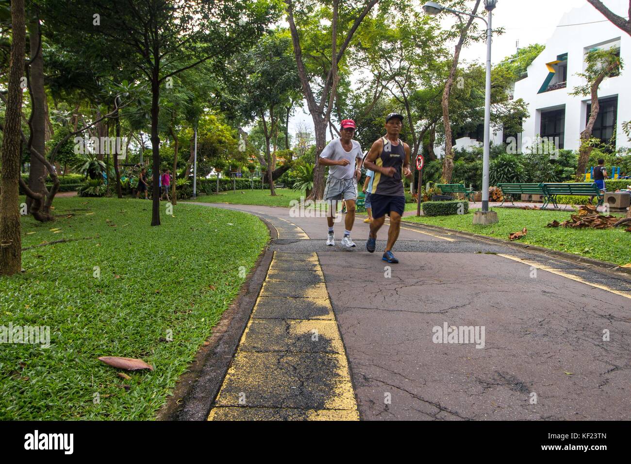 Two Thai joggers running on a path at Benchasiri Park Stock Photo - Alamy