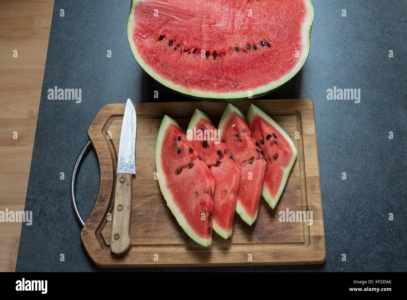 Half watermelon with slices on the wooden board Stock Photo - Alamy