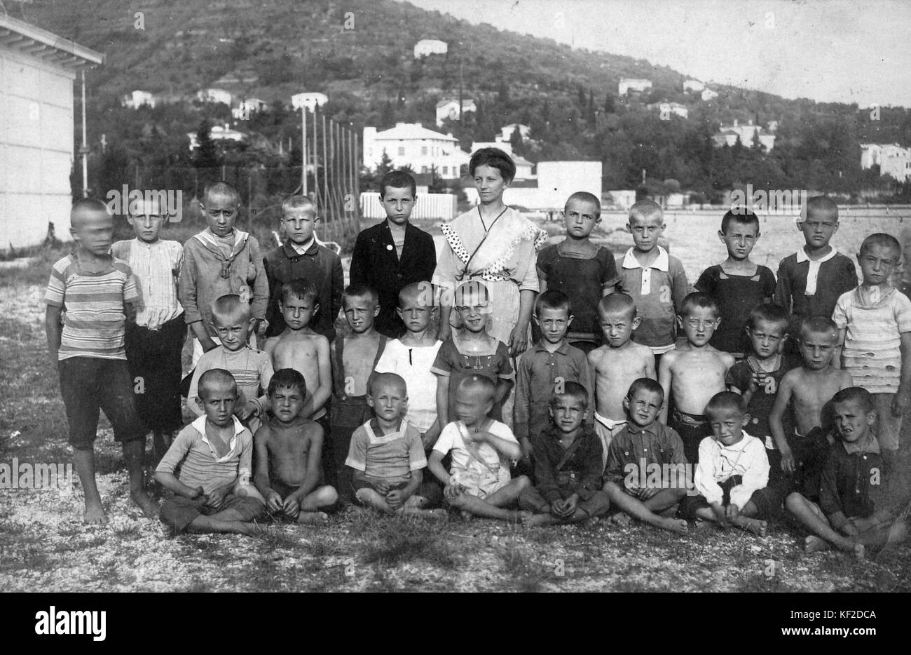 A historical class photo featuring a woman teacher, showcasing a ...