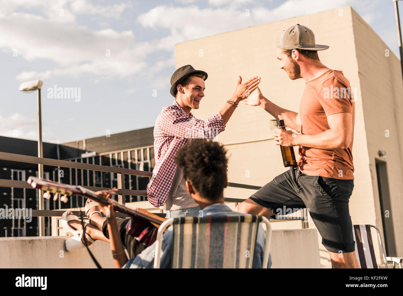 Three friends having a rooftop party Stock Photo - Alamy