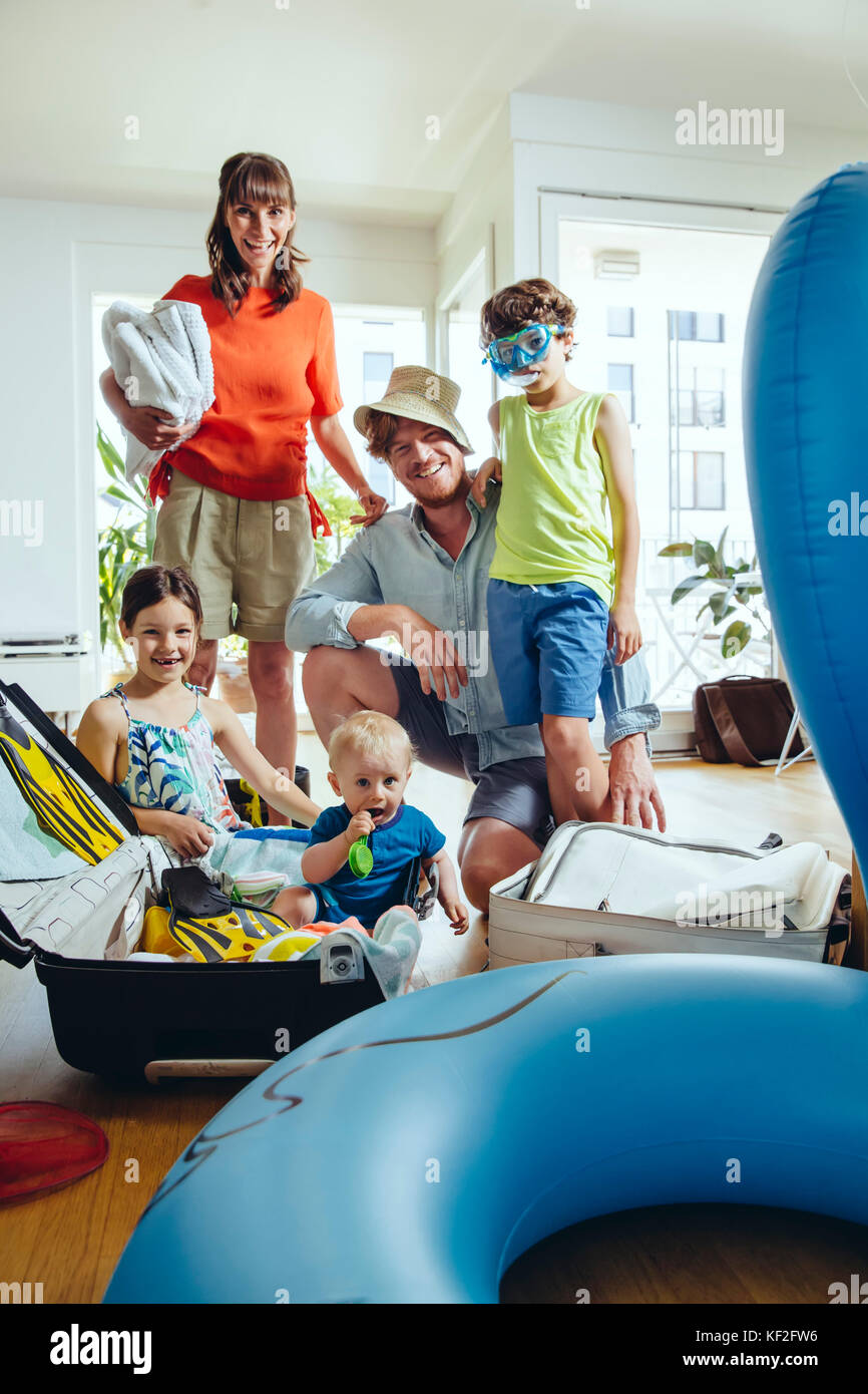 Happy family of five packing for holiday trip Stock Photo - Alamy