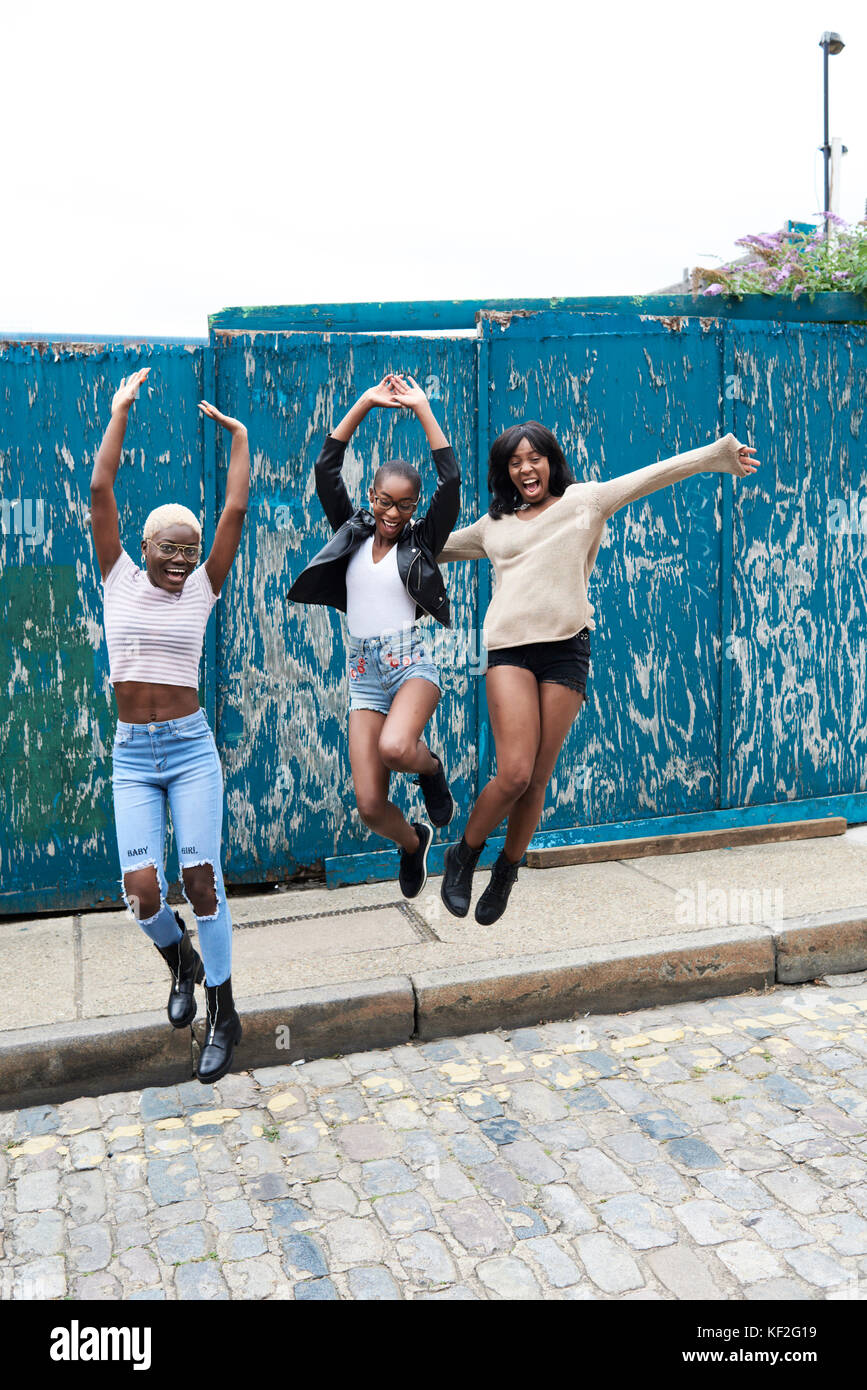 Three friends having fun jumping in the air Stock Photo - Alamy