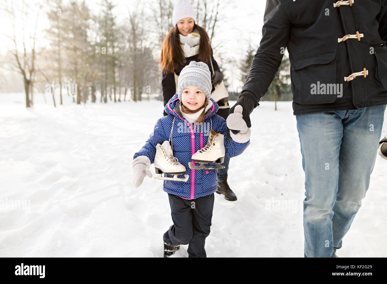 Little girl going ice skating with her parents Stock Photo - Alamy
