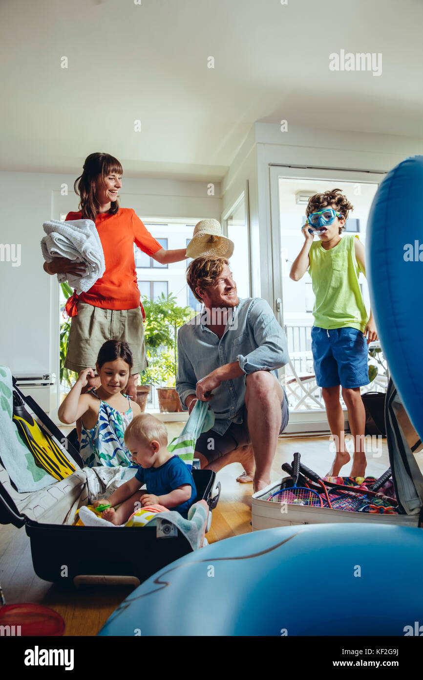 Happy family of five packing for holiday trip Stock Photo - Alamy