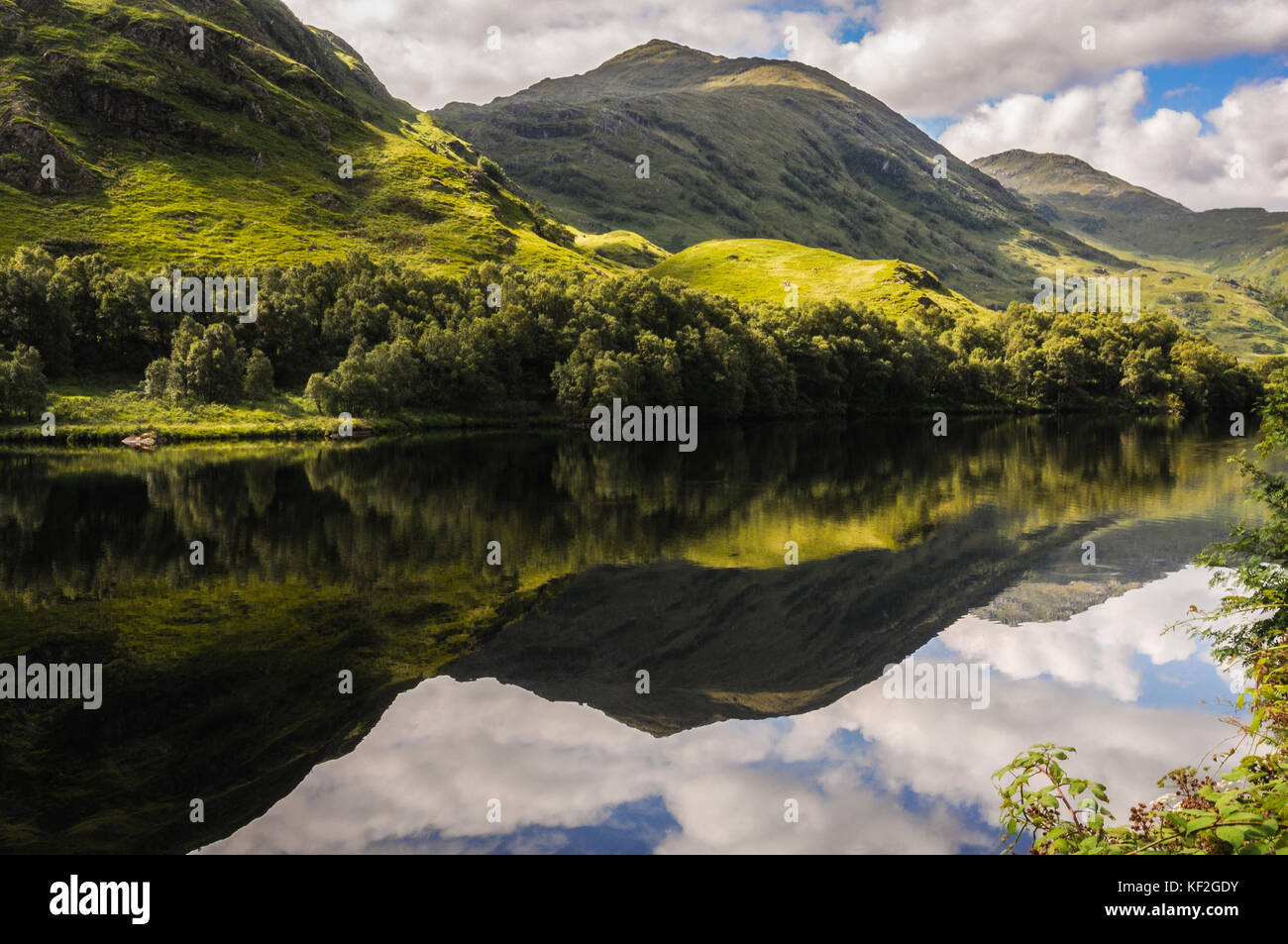 Reflections in the still water of Loch Eilt, a freshwater loch in ...