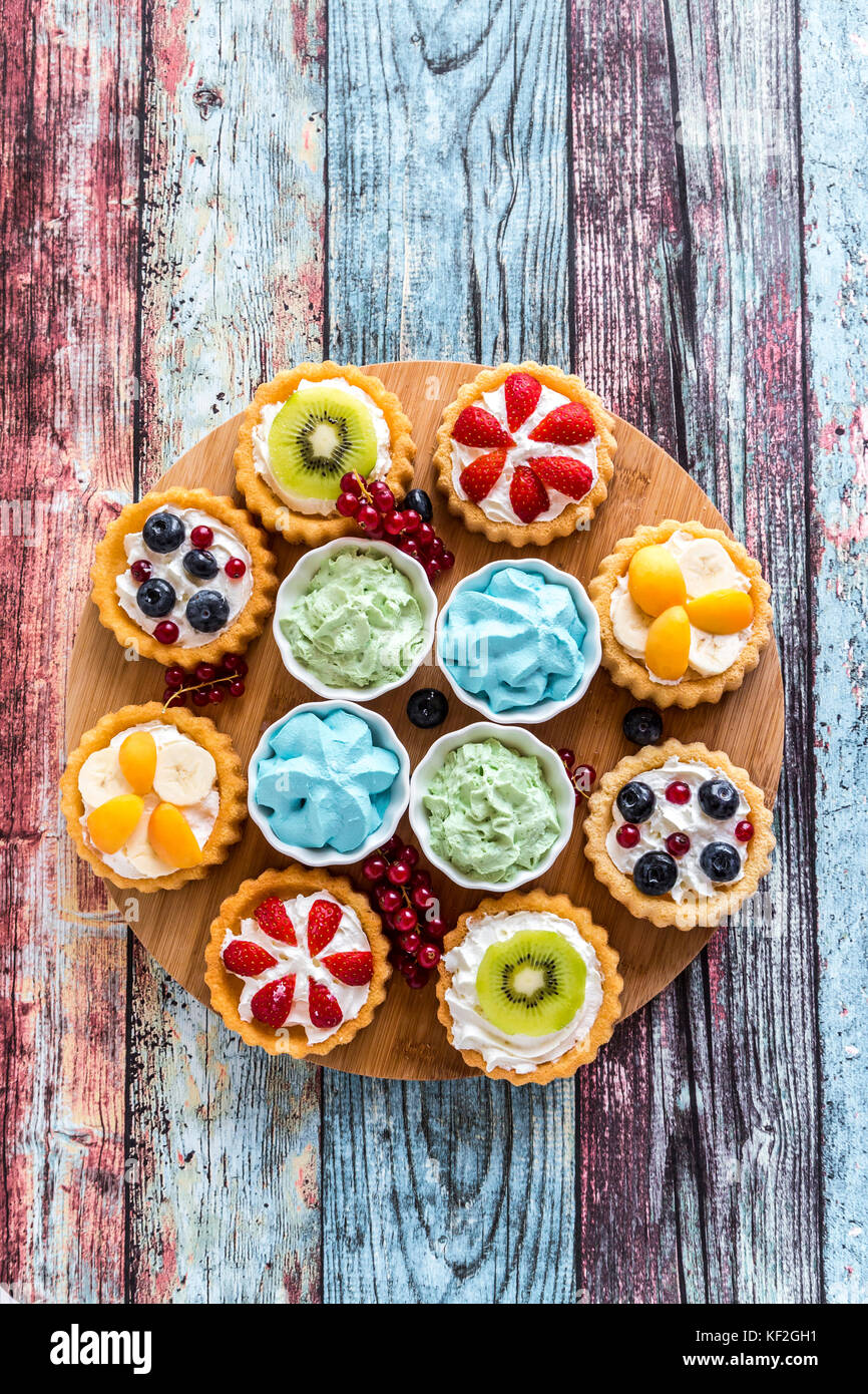 Mini pies with whipped cream garnished with different fruits Stock ...