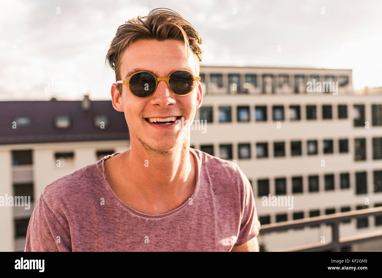 Portrait of happy young man on rooftop Stock Photo - Alamy