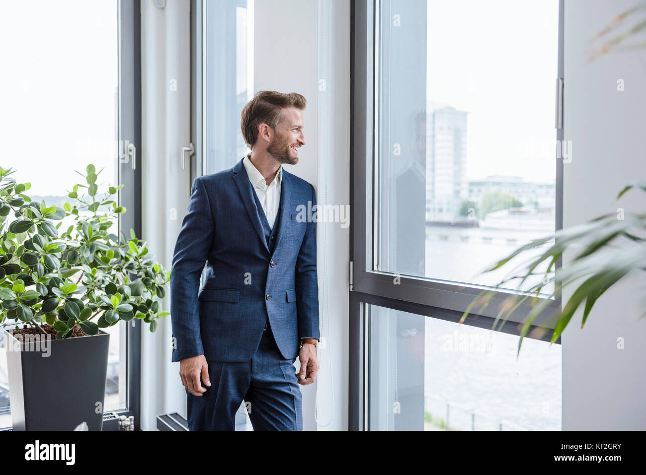 Businessman standing window looking distance hi-res stock photography ...