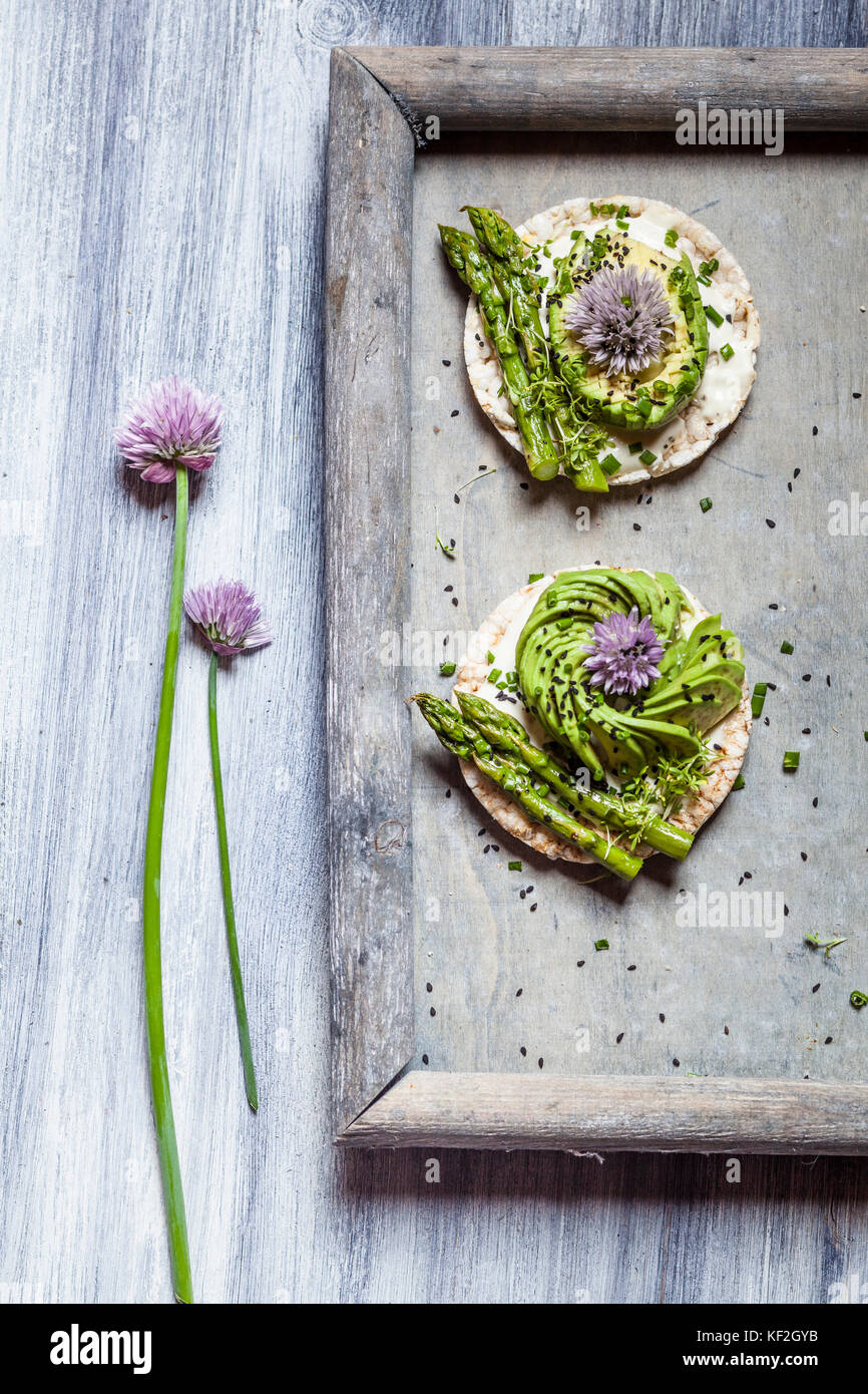Rice cakes with cream cheese, avocado and asparagus garnished with ...