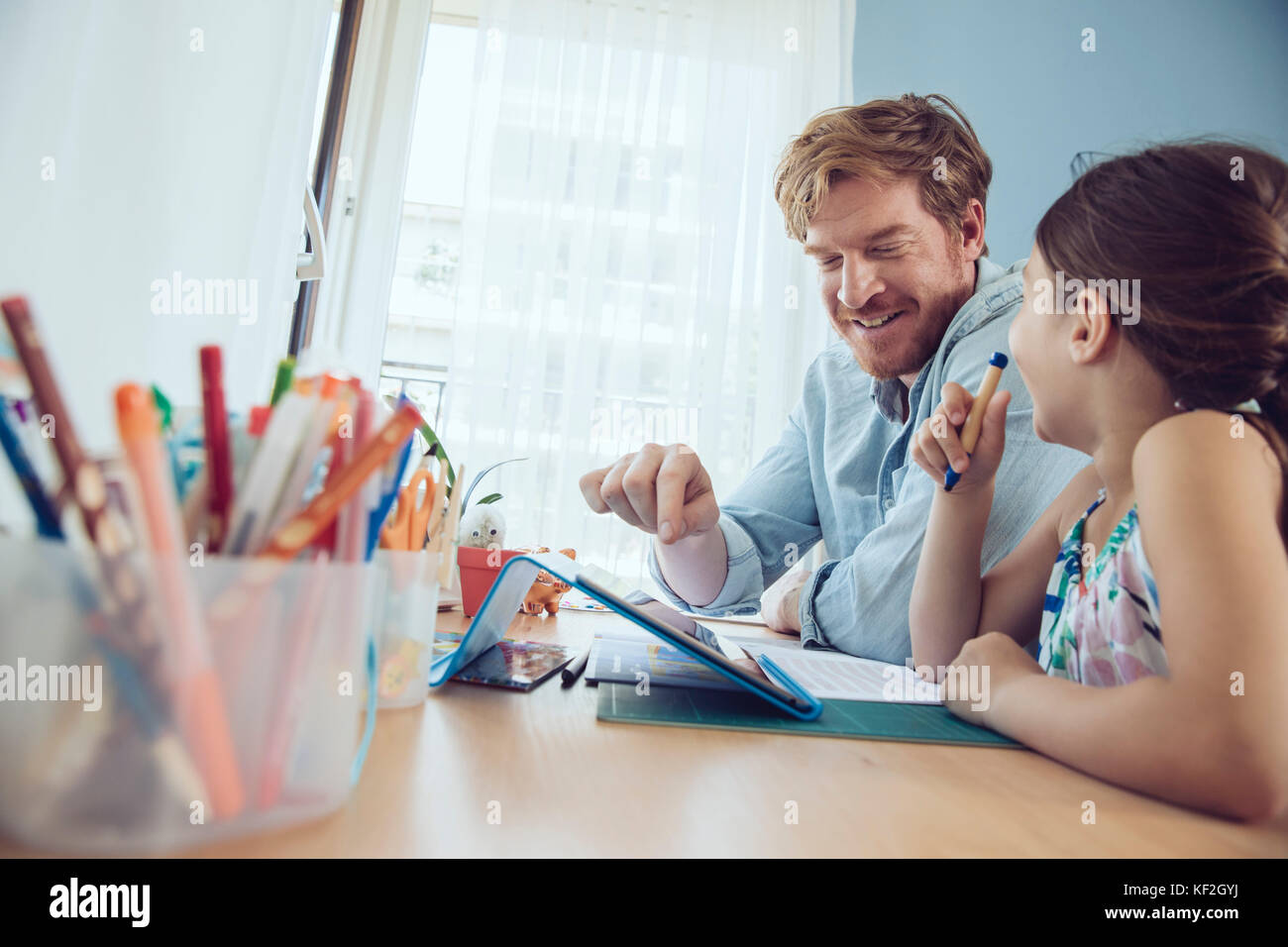 Father and daughter using tablet at home Stock Photo - Alamy