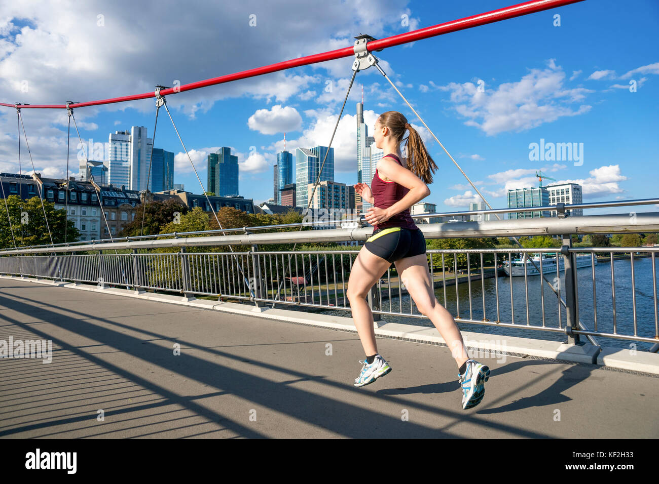 Germany, Frankfurt, young woman running on bridge Stock Photo - Alamy