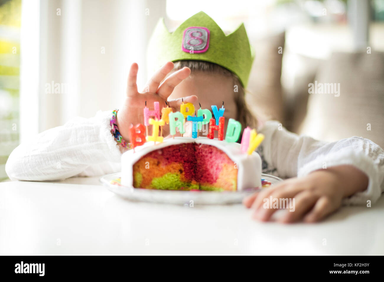 Girl hiding behind birthday cake Stock Photo - Alamy