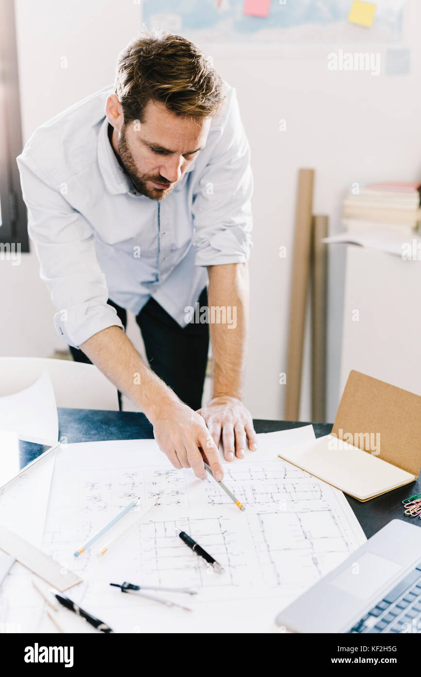 Architect working on construction plan Stock Photo - Alamy