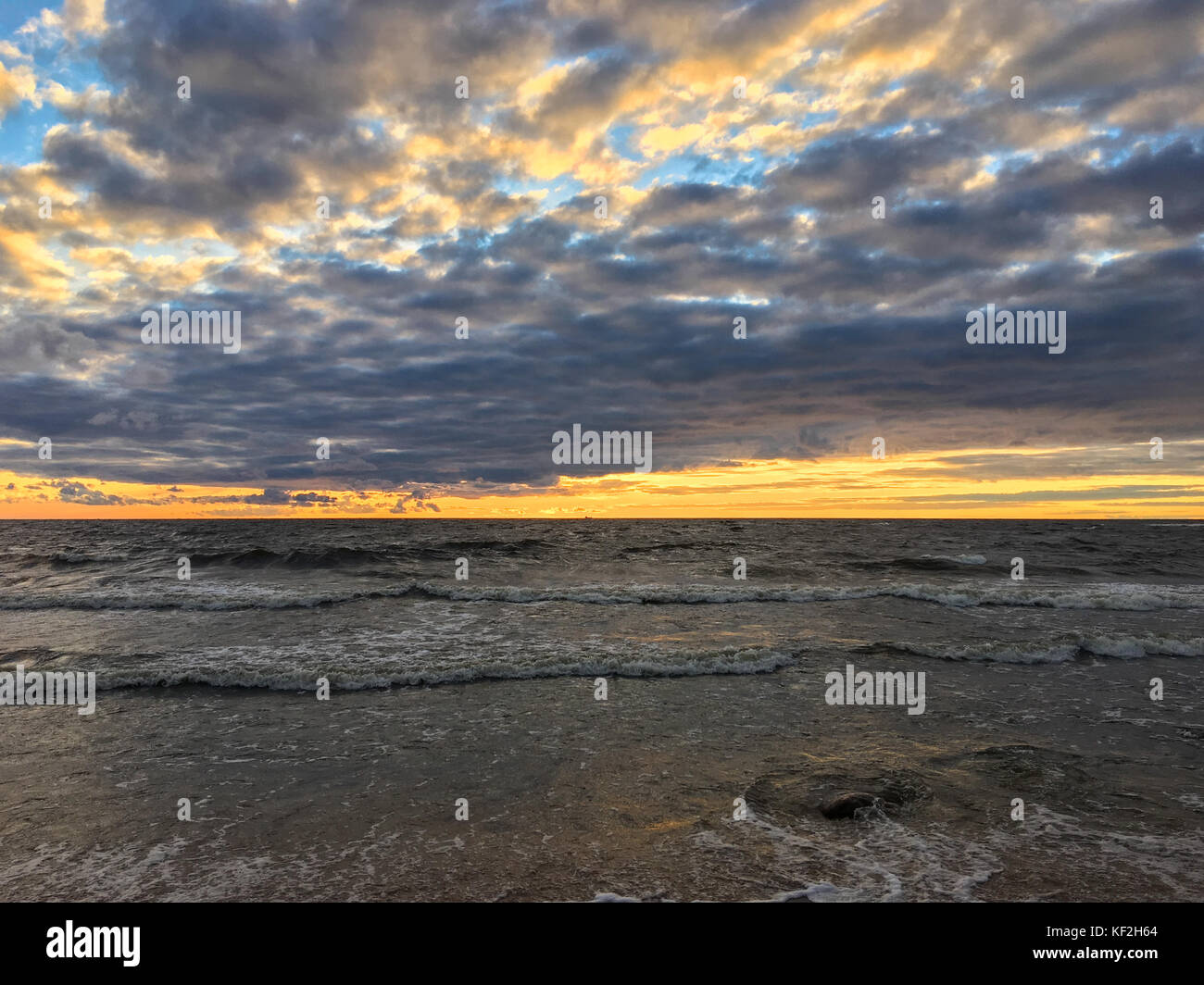 Dark sea waves run across the sandy beach at sunset, the Gulf of ...