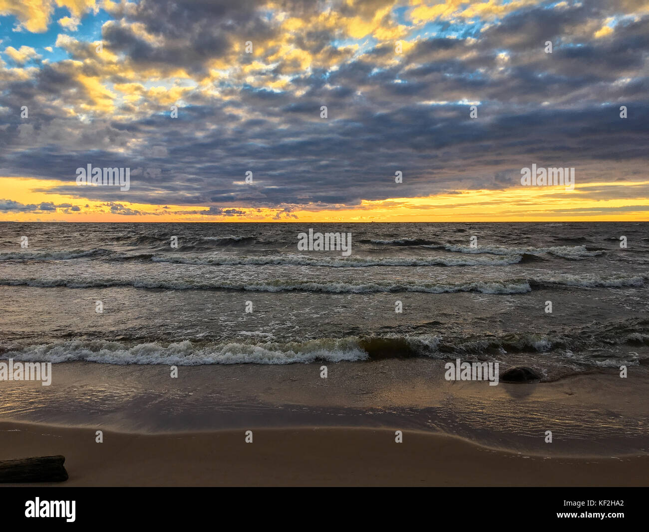 Sandy beach with grey sea waves on stormy Gulf of Finland, sunset sky ...