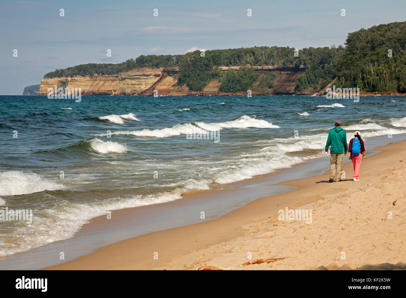 Munising, Michigan - Two people walk along the beach of Lake Superior ...
